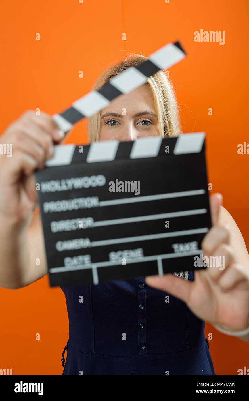 Woman holding an movie clapper in studio Stock Photo - Alamy