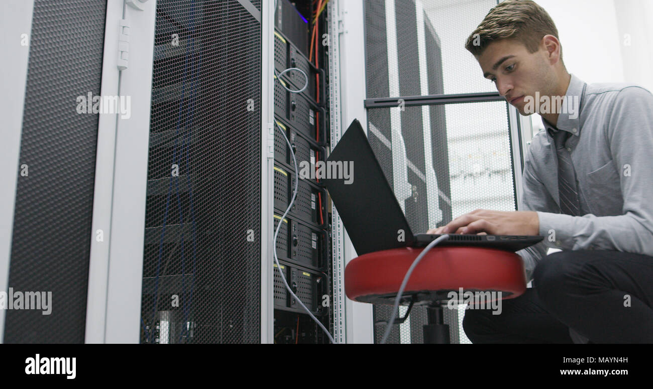 Technician performing maintenance tasks in a server room rack Stock ...