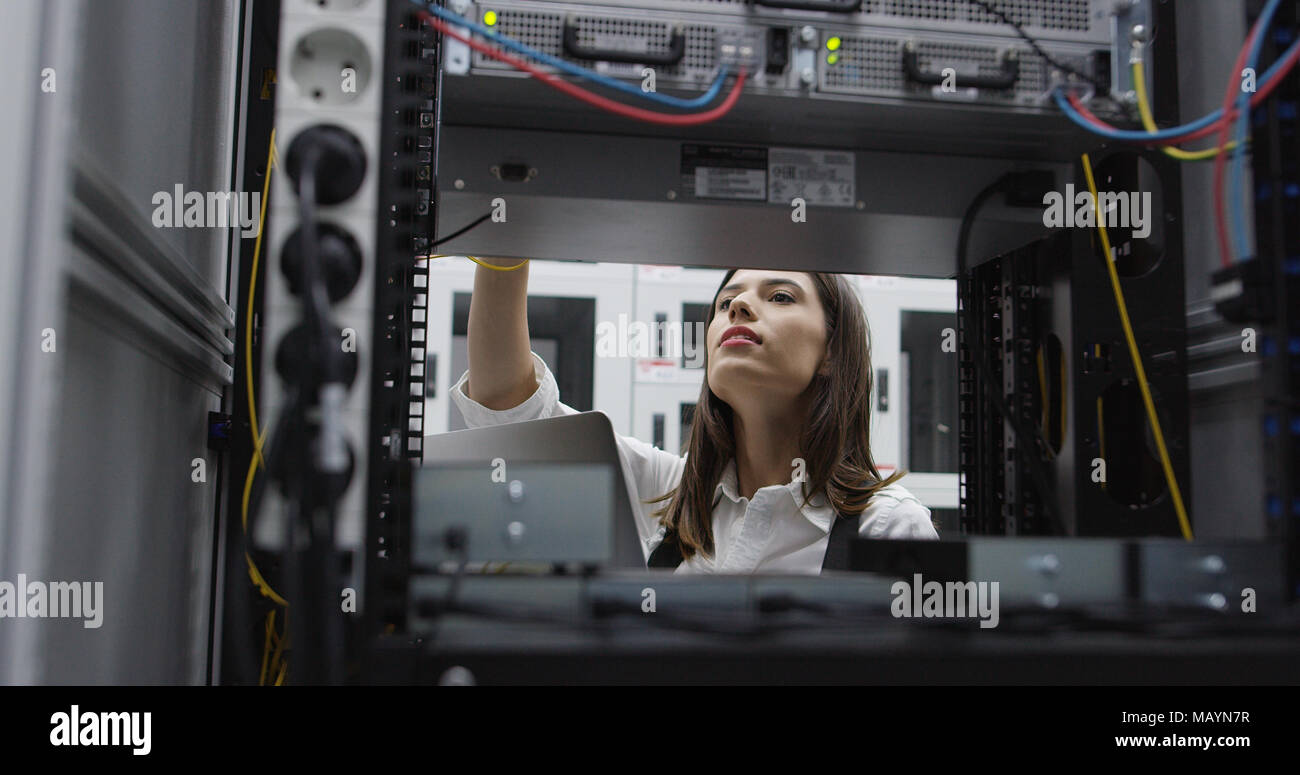 Technician performing maintenance tasks in a server room rack Stock ...