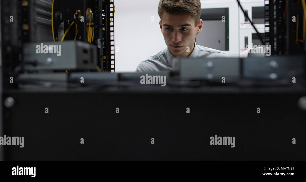 Technician performing maintenance tasks in a server room rack Stock ...