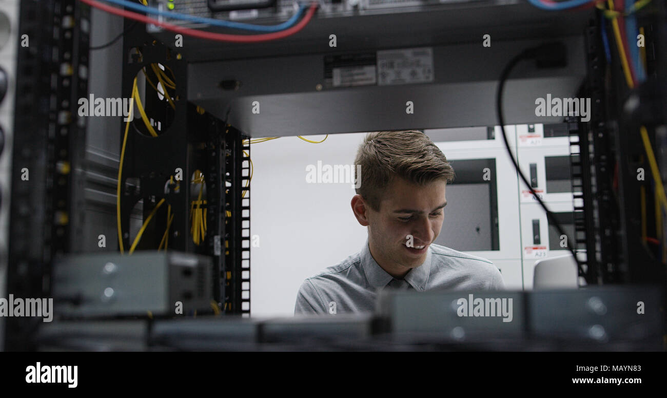 Technician performing maintenance tasks in a server room rack Stock ...