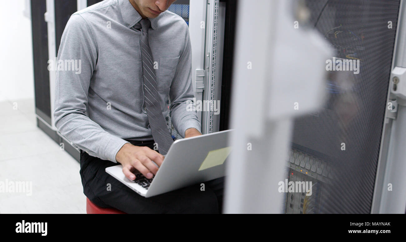 Technician performing maintenance tasks in a server room rack Stock ...