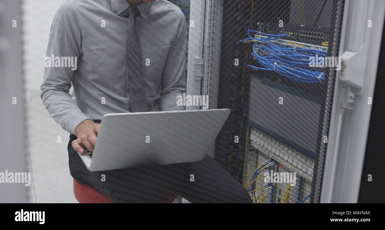 Technician performing maintenance tasks in a server room rack Stock ...