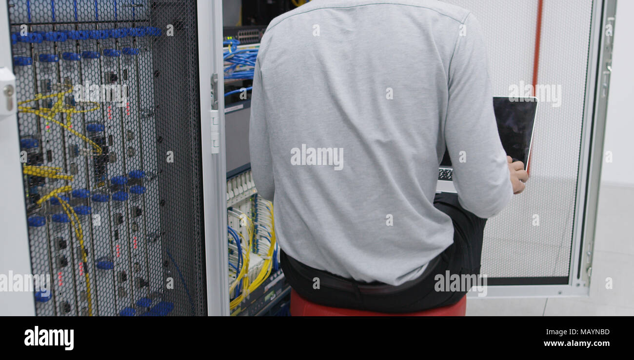 Technician performing maintenance tasks in a server room rack Stock ...