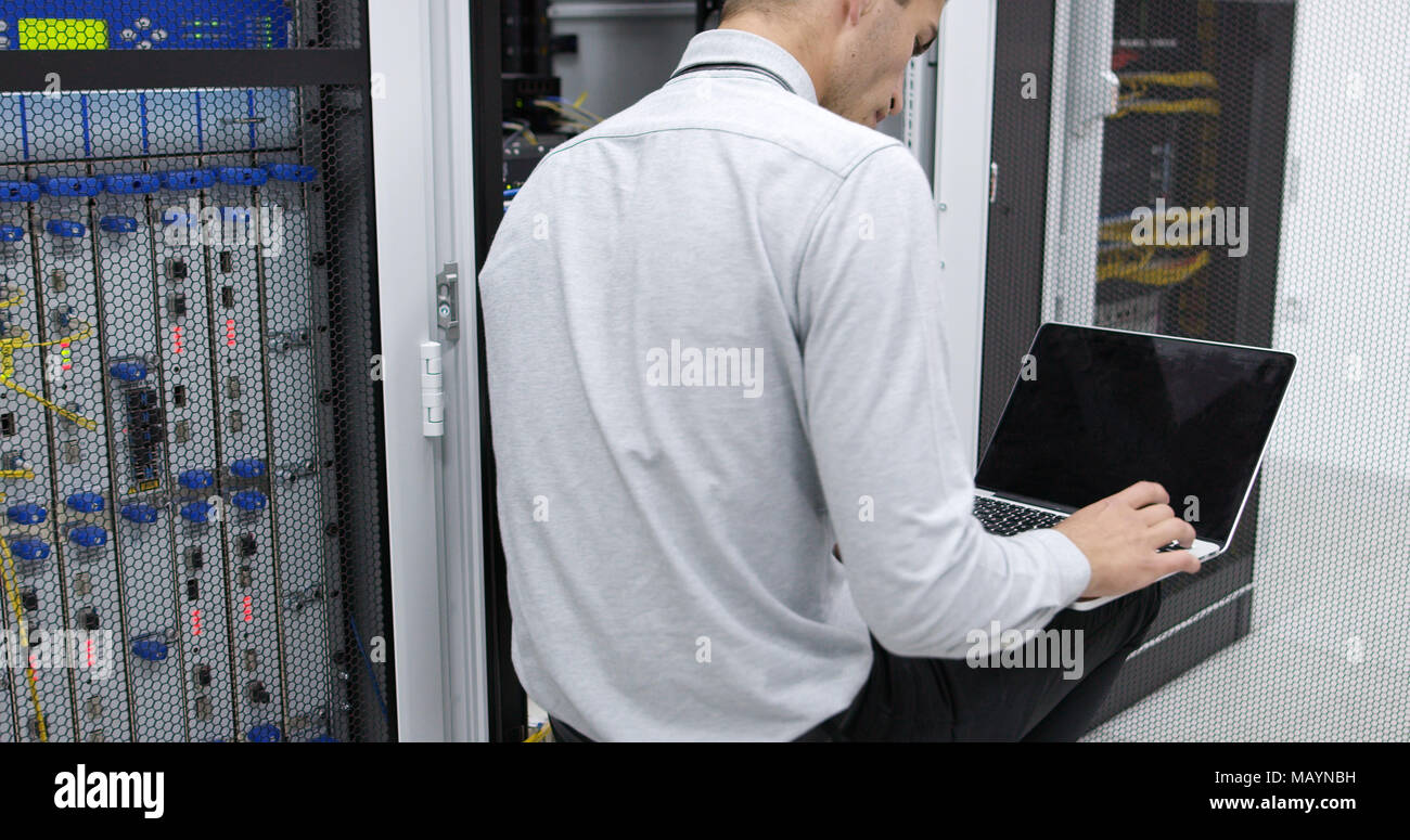 Technician performing maintenance tasks in a server room rack Stock ...