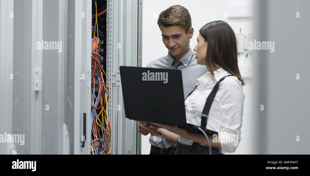 Technicians Using Laptop While Analyzing Server In Server Room Stock 9895