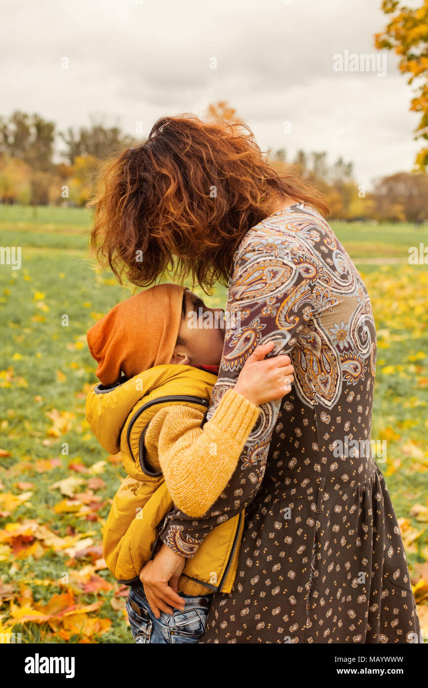 Happy Autumn Family. Cute Mother and Son Hugging in Fall Park Outdoors ...
