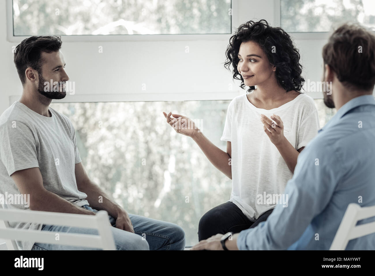 Positive young people sitting together Stock Photo - Alamy