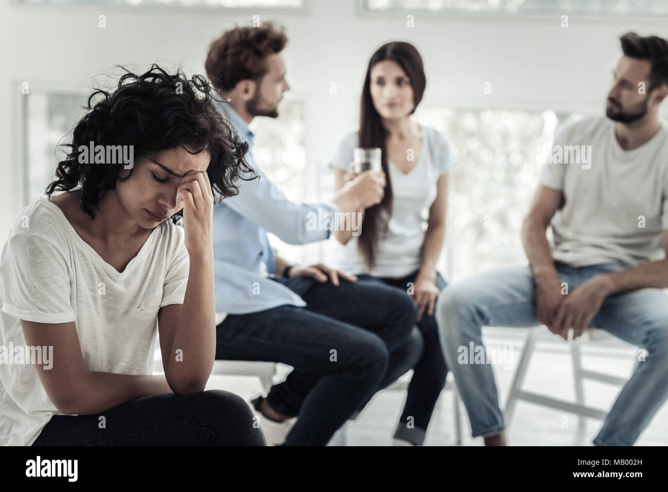 Depressed young woman holding her forehead Stock Photo - Alamy