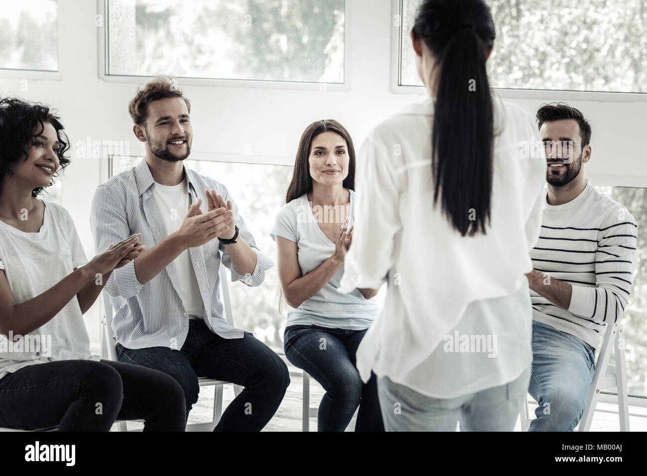 Joyful happy people looking at their team leader Stock Photo - Alamy