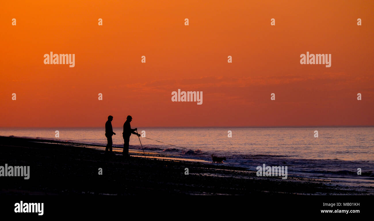 Three friends on beach at sunset Stock Photo - Alamy