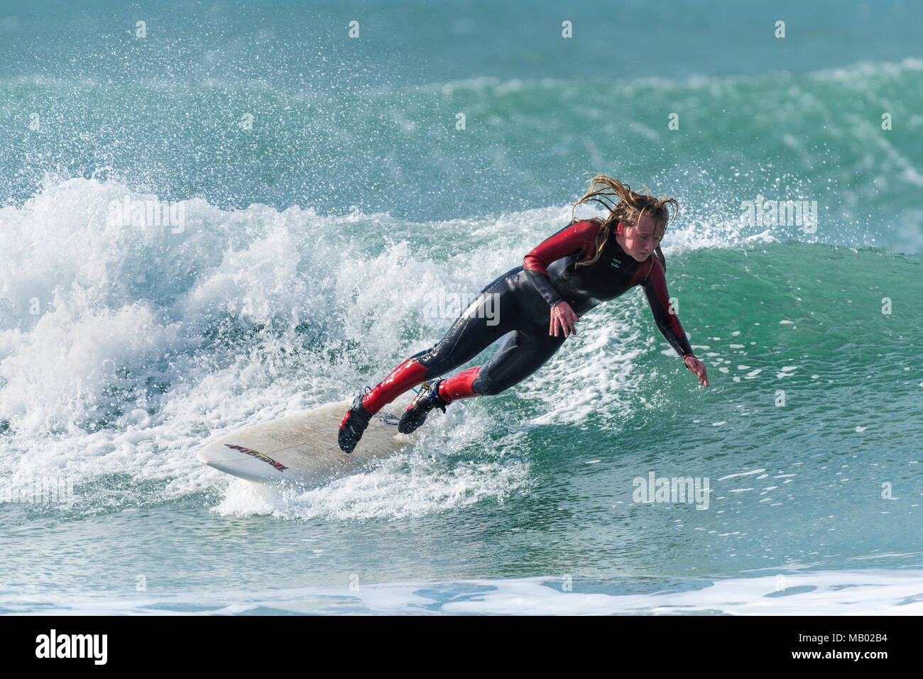 A surfer falling off a surfboard in cold wintry conditions at Fistral ...