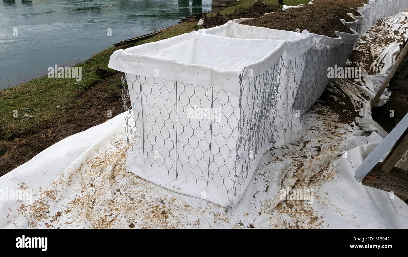 Setting up new sandbox barriers flood protection next to mighty river ...