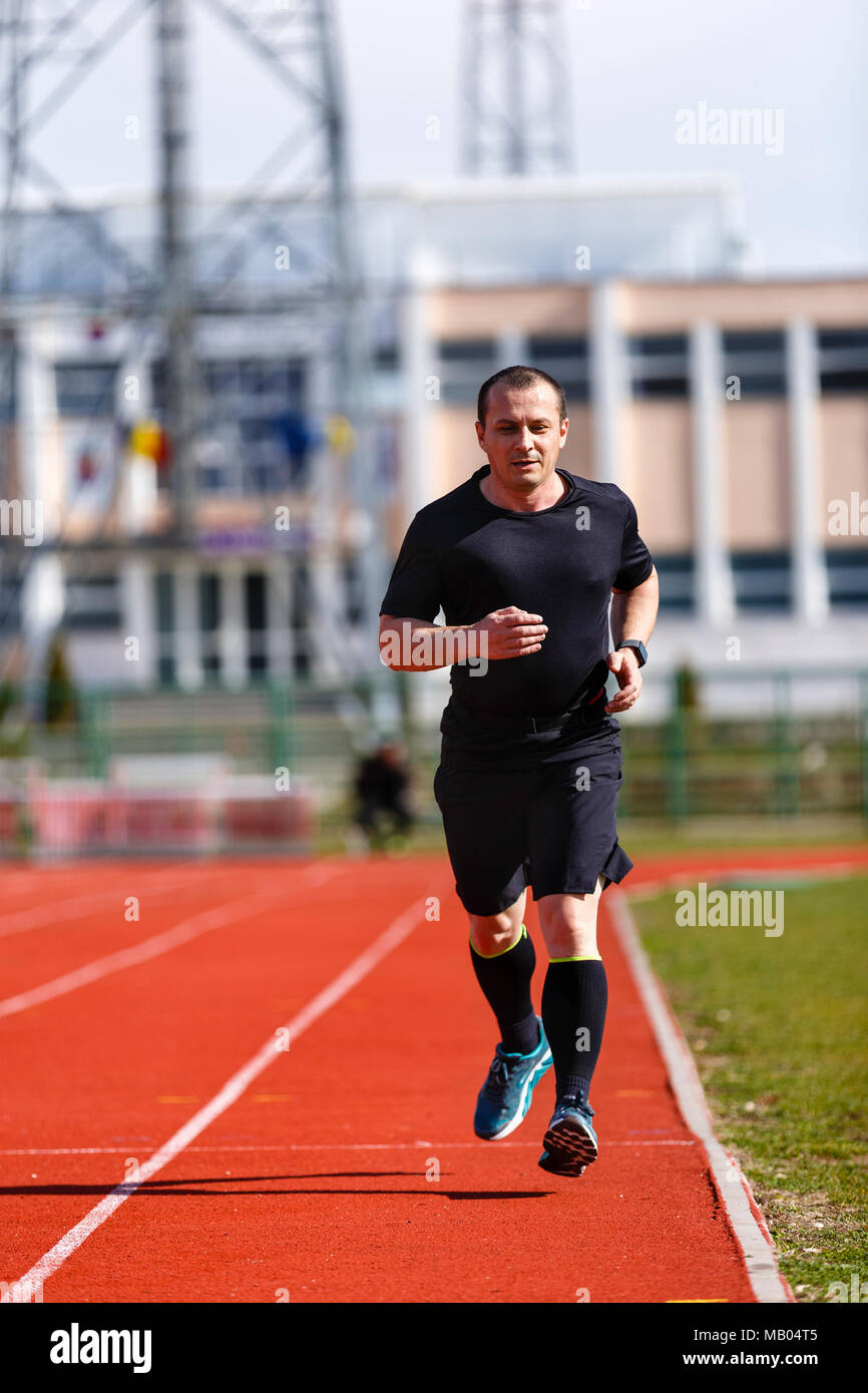 Male sprinter in middle age trains for race competition Stock Photo - Alamy