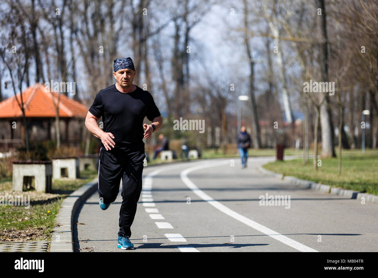 A middle-aged man running through the park Stock Photo - Alamy