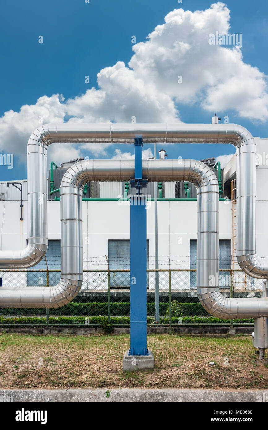 Steam distribution pipeline on factories background Stock Photo - Alamy