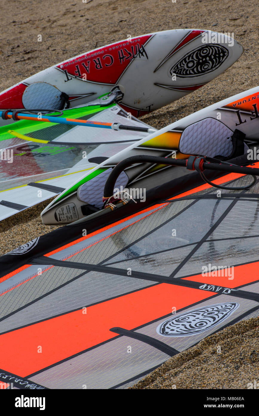 modern and brightly coloured wind surf boards and sails on the beach ...