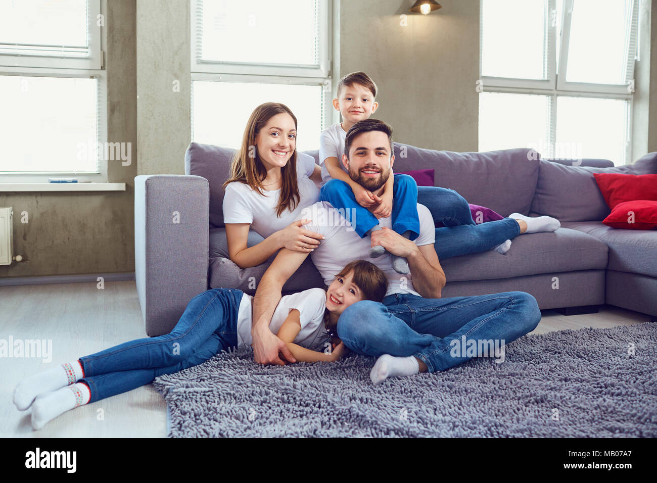 Happy family smiling sitting at home Stock Photo - Alamy