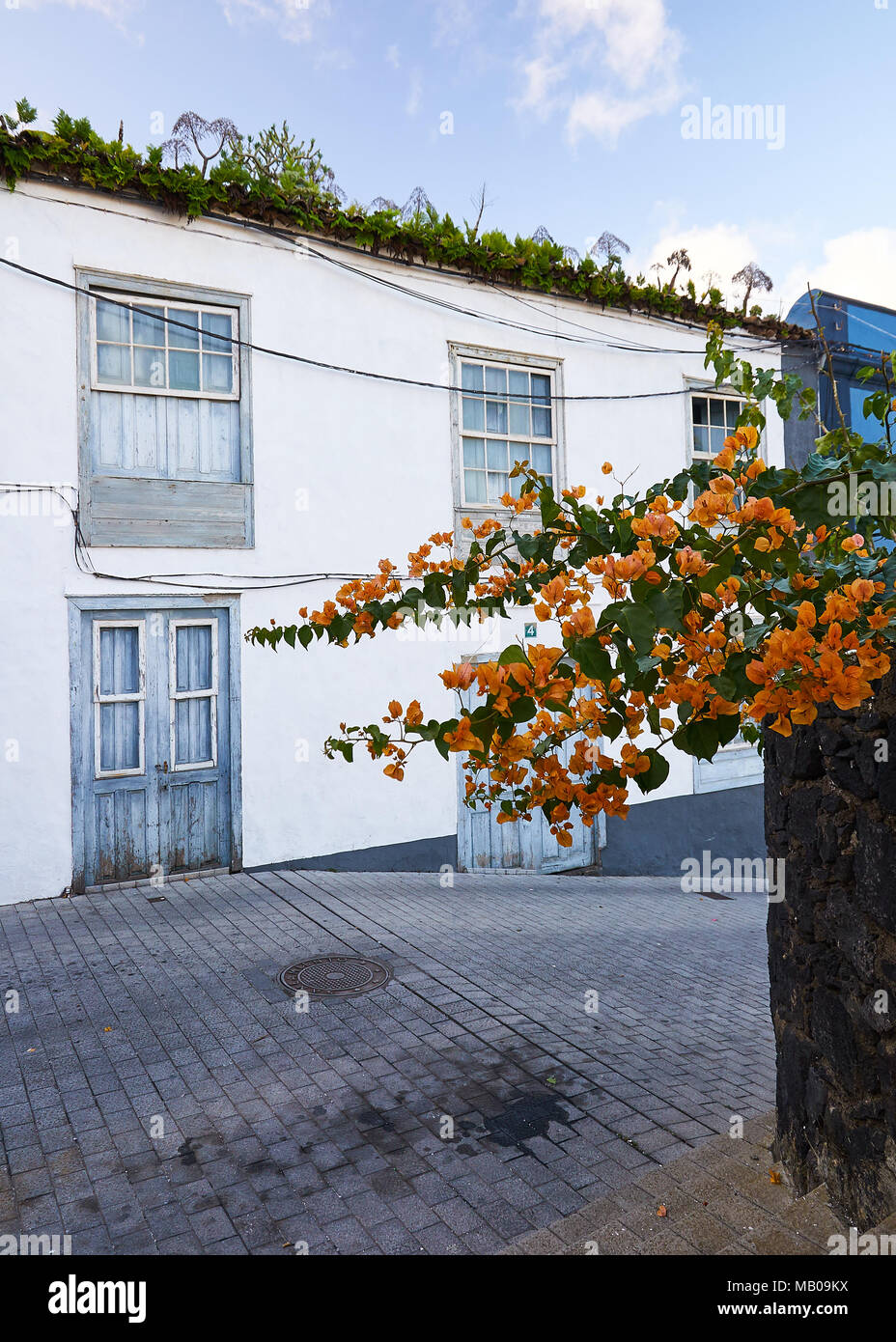 Old typical house with blue wood windows and door and orange ...
