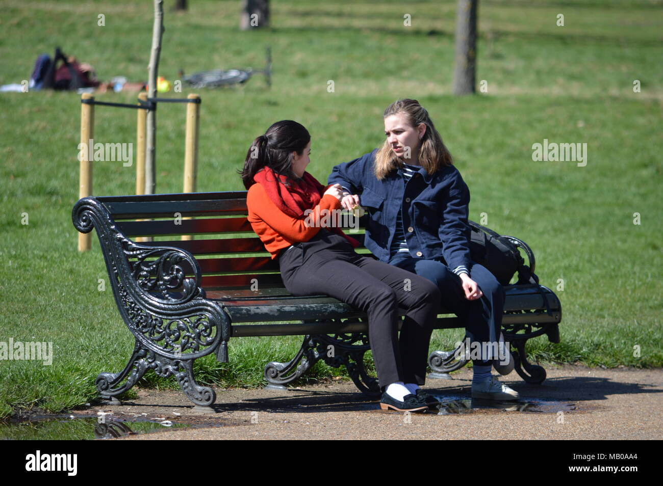 Two girls talking on bench hi-res stock photography and images - Alamy