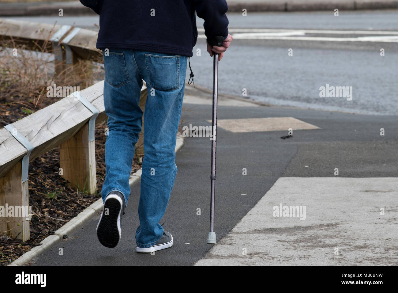 An elderly man walks with a walking stick Stock Photo - Alamy