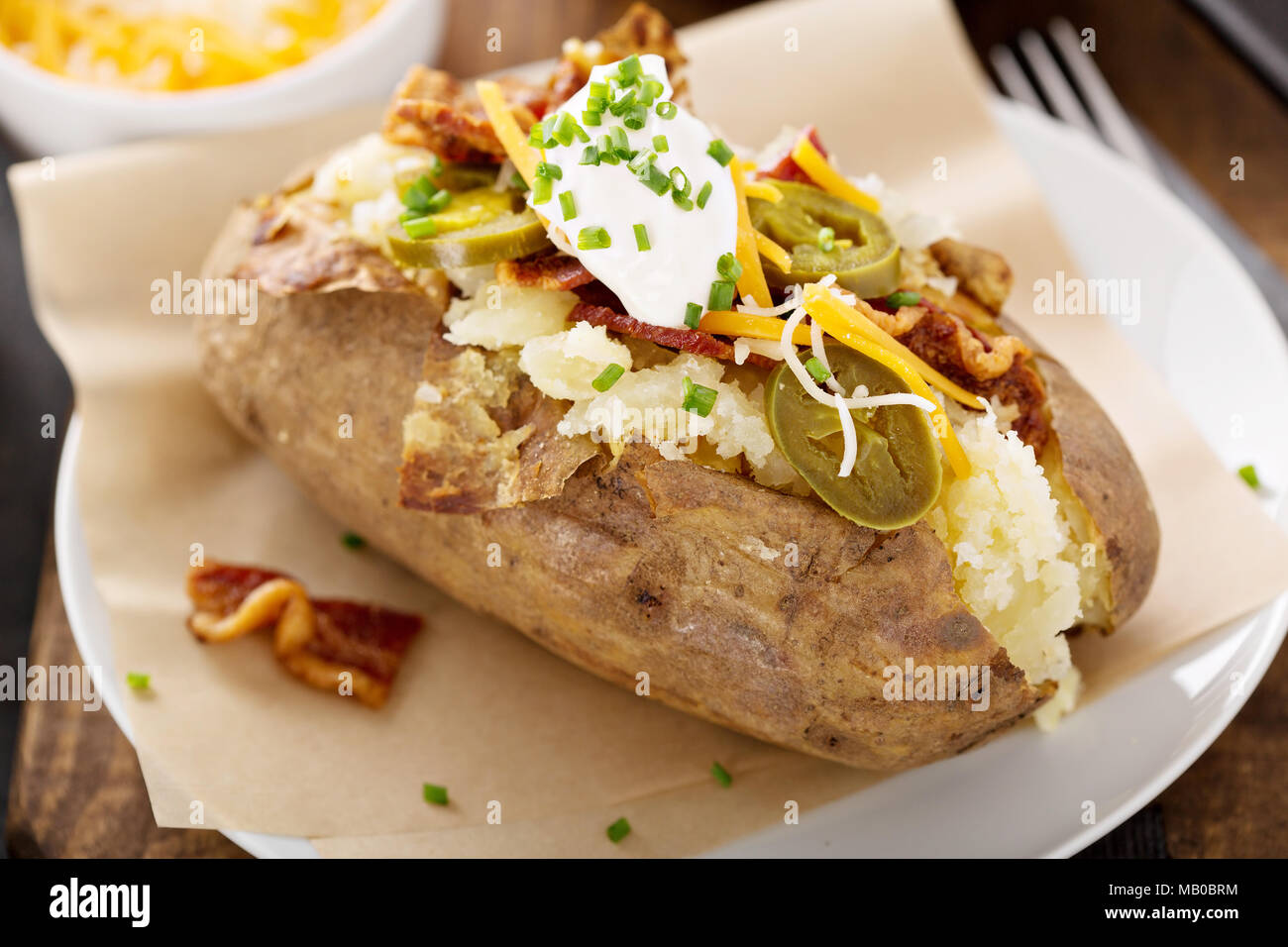 Loaded baked potato with bacon, cheese sour cream and chives Stock ...