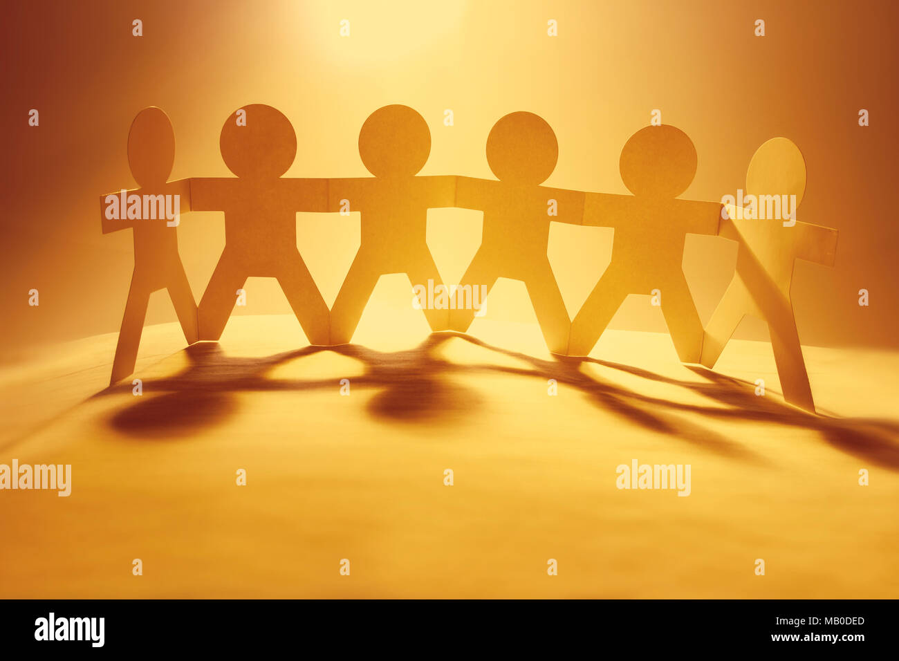 Team of paper chain people in a row holding hands Stock Photo - Alamy