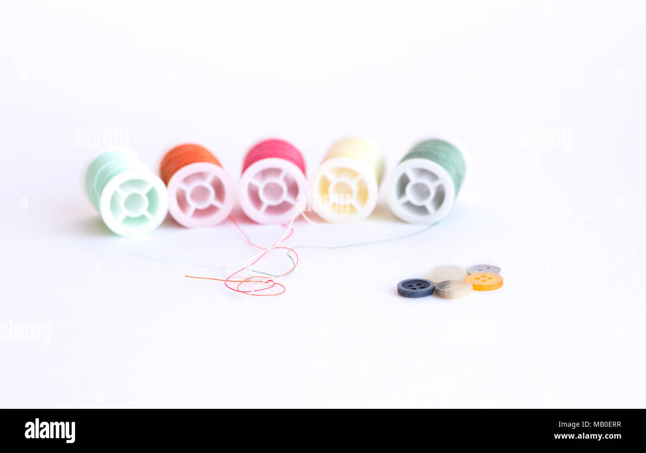 Colorful sewing thread reels and fashion buttons isolated on a white ...