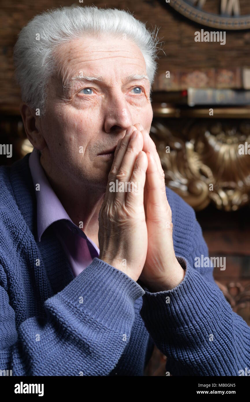 Portrait of sad senior man praying Stock Photo - Alamy