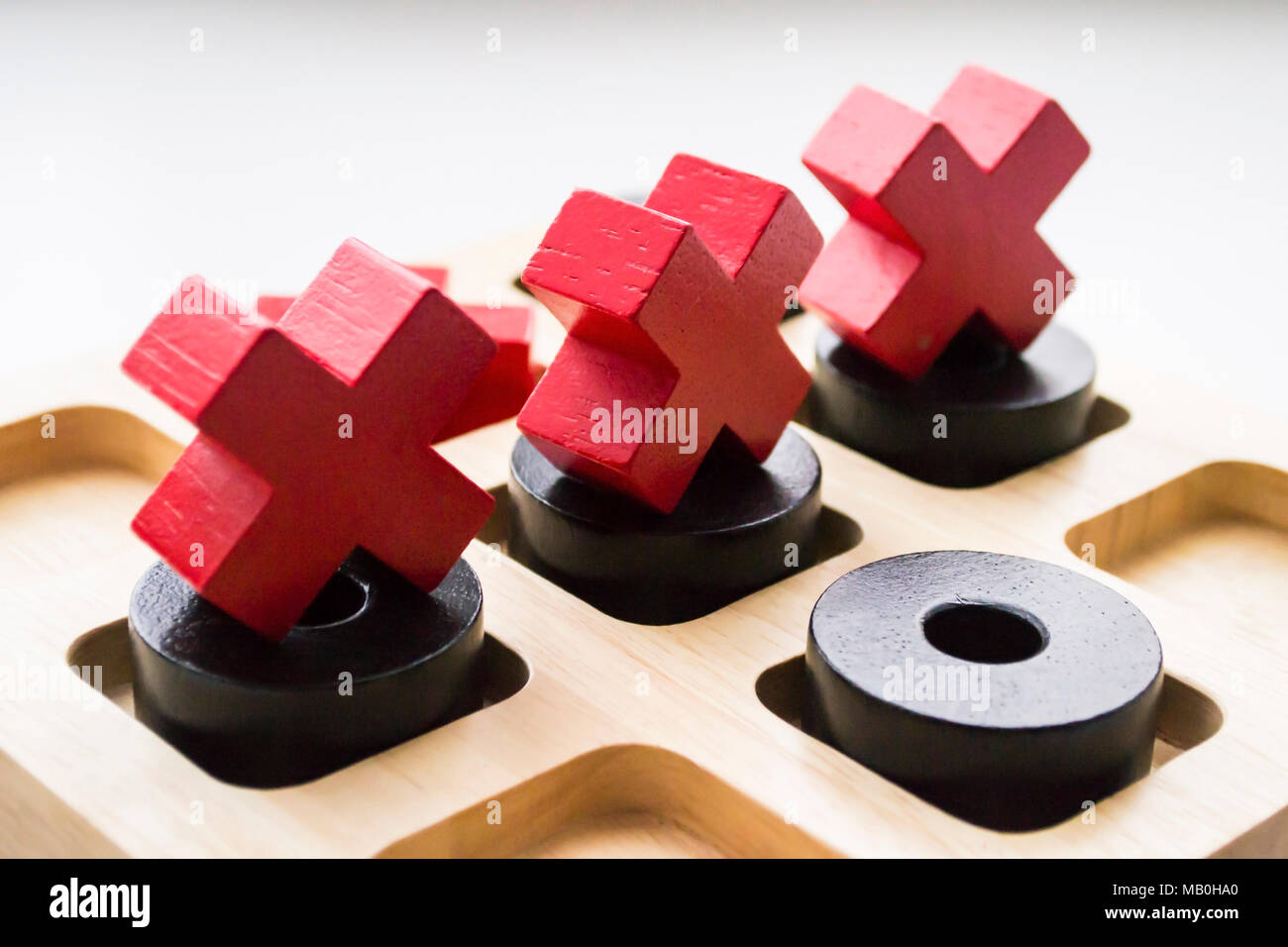 Wooden tic tac toe game on white background. Three red crosses on black ...