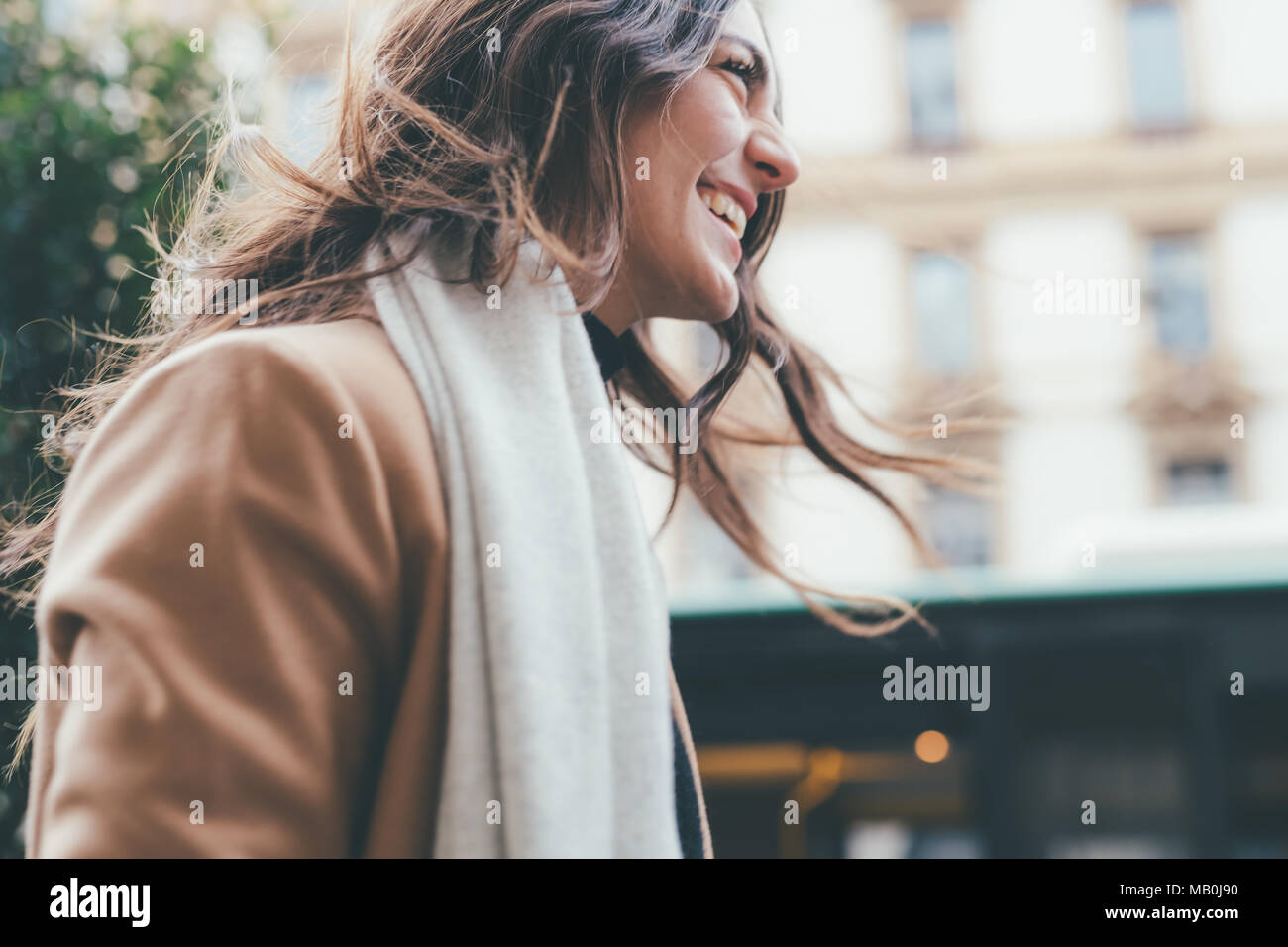 young woman walking outdoors smiling - happiness, positive emotions ...
