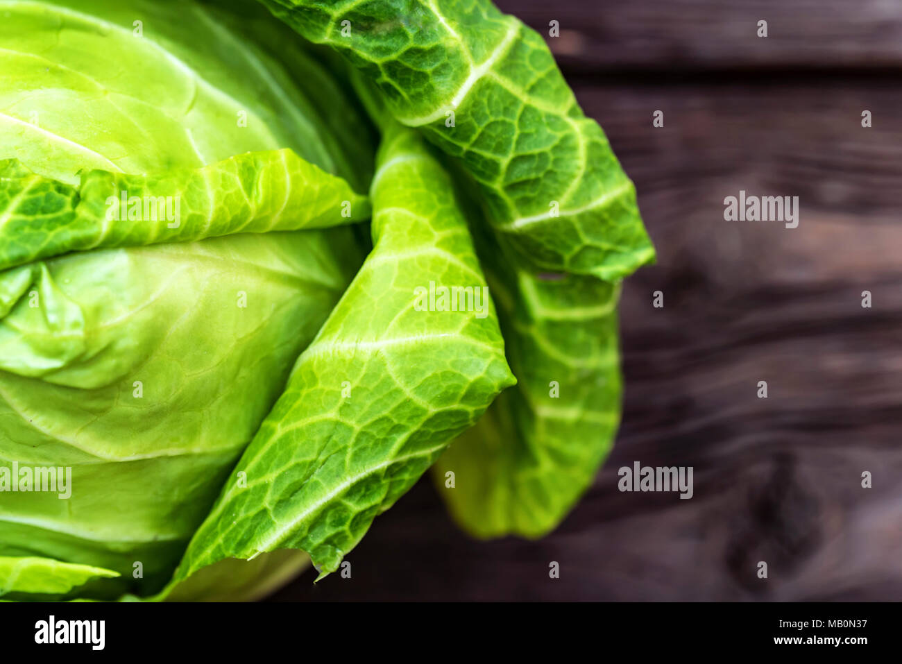 Green fresh cabbage head on wooden surface Stock Photo - Alamy