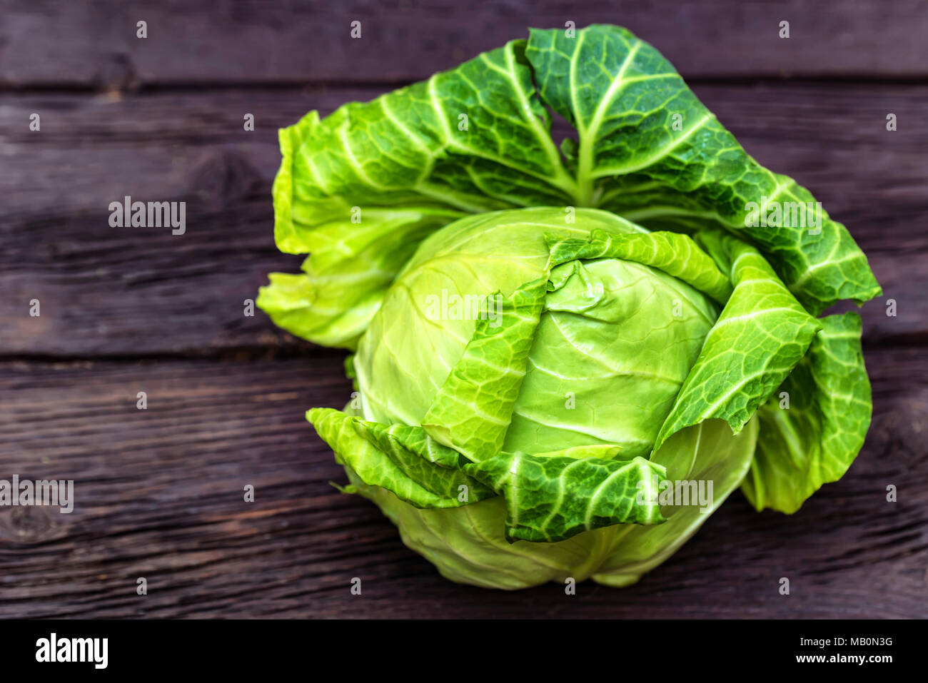Green fresh cabbage head on wooden surface Stock Photo - Alamy