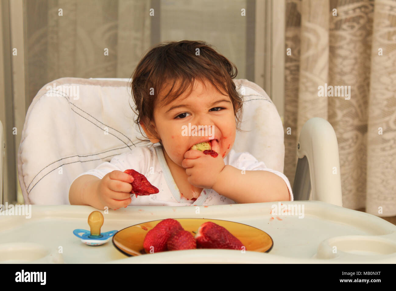 One year old baby boy eating strawberryes for the first time Stock ...