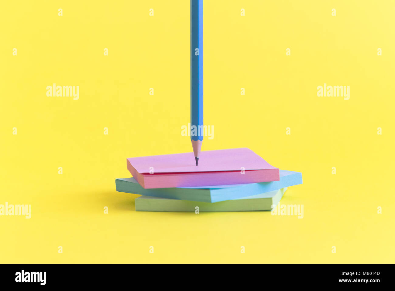 Sticky notes in different colors with pencil on yellow background ...