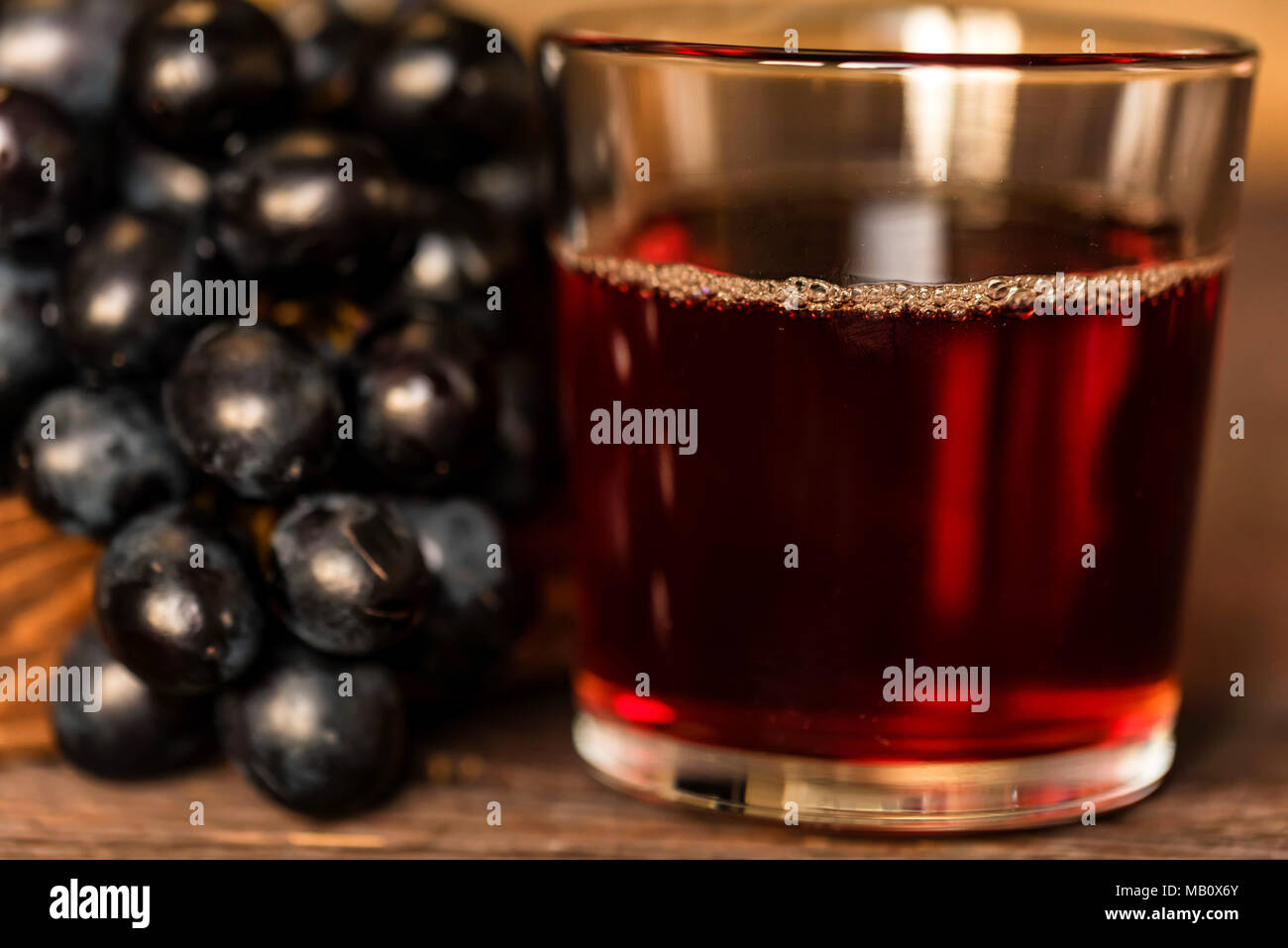 Red grape juice in glass and grapes close Stock Photo - Alamy
