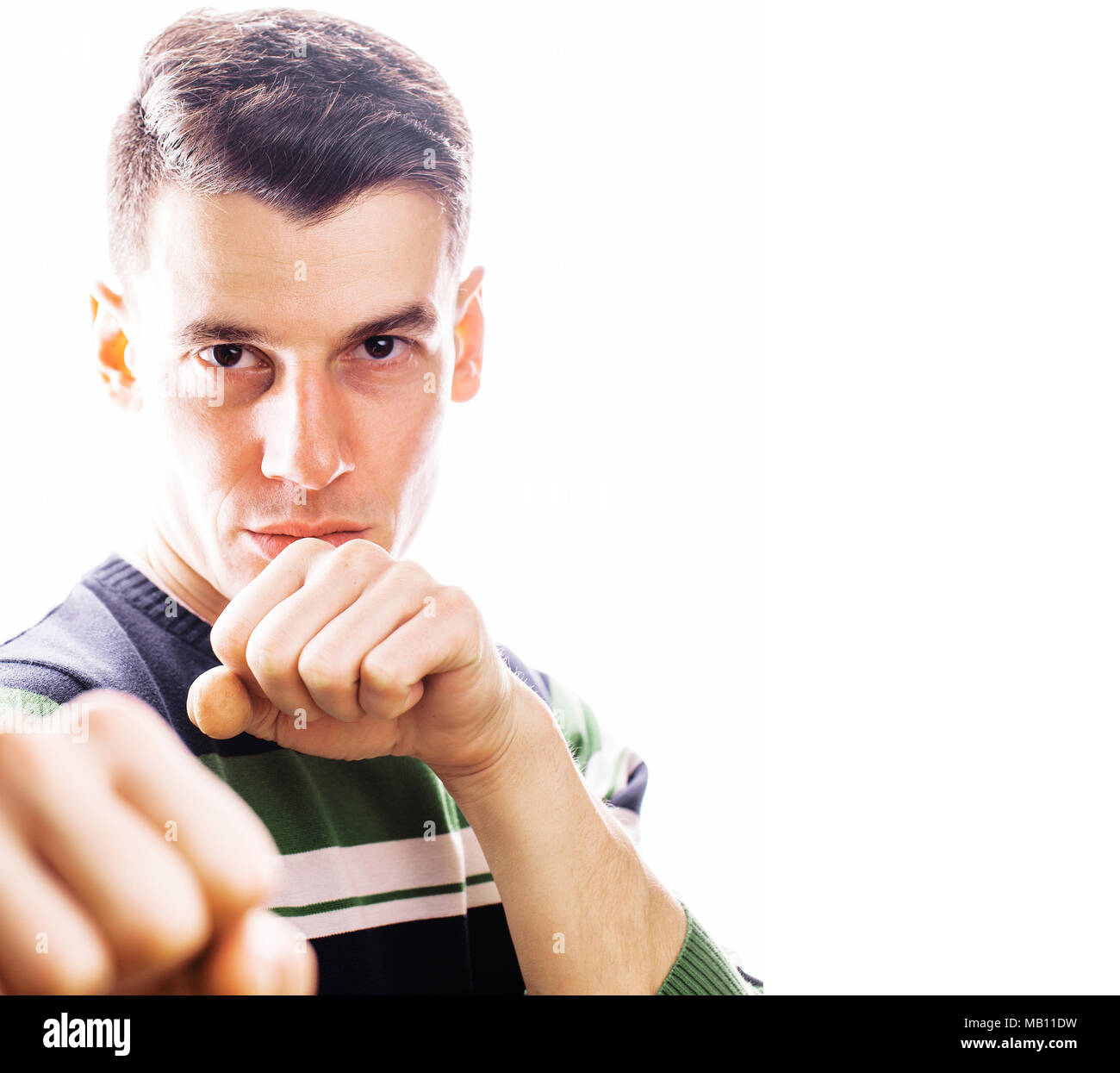 Portrait of a smart serious young man standing against white bac Stock ...
