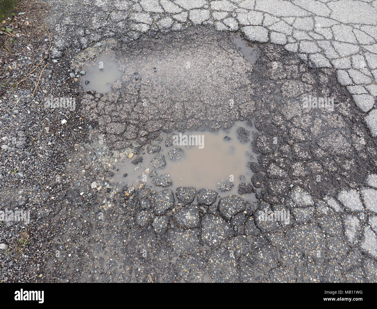 Pothole in a street caused by failure primarily in asphalt pavement ...