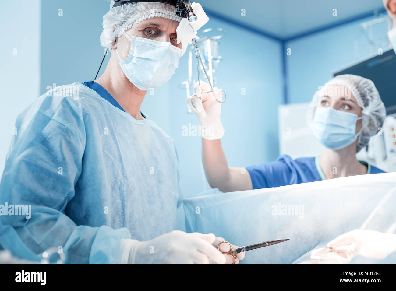 Smart professional doctor performing an operation Stock Photo - Alamy