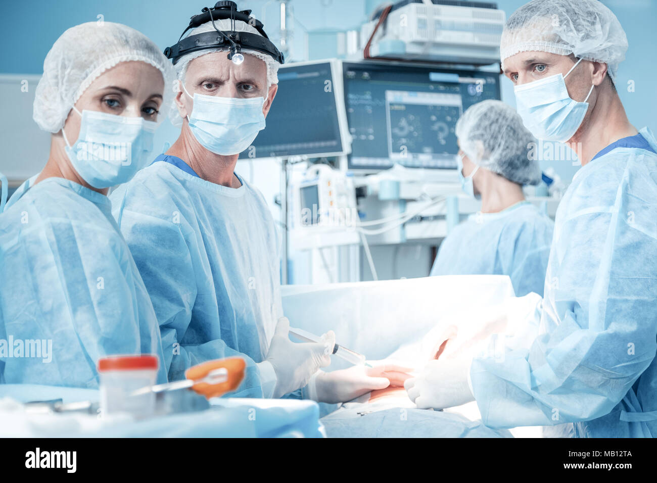 Smart nice surgeons saving the patient Stock Photo - Alamy