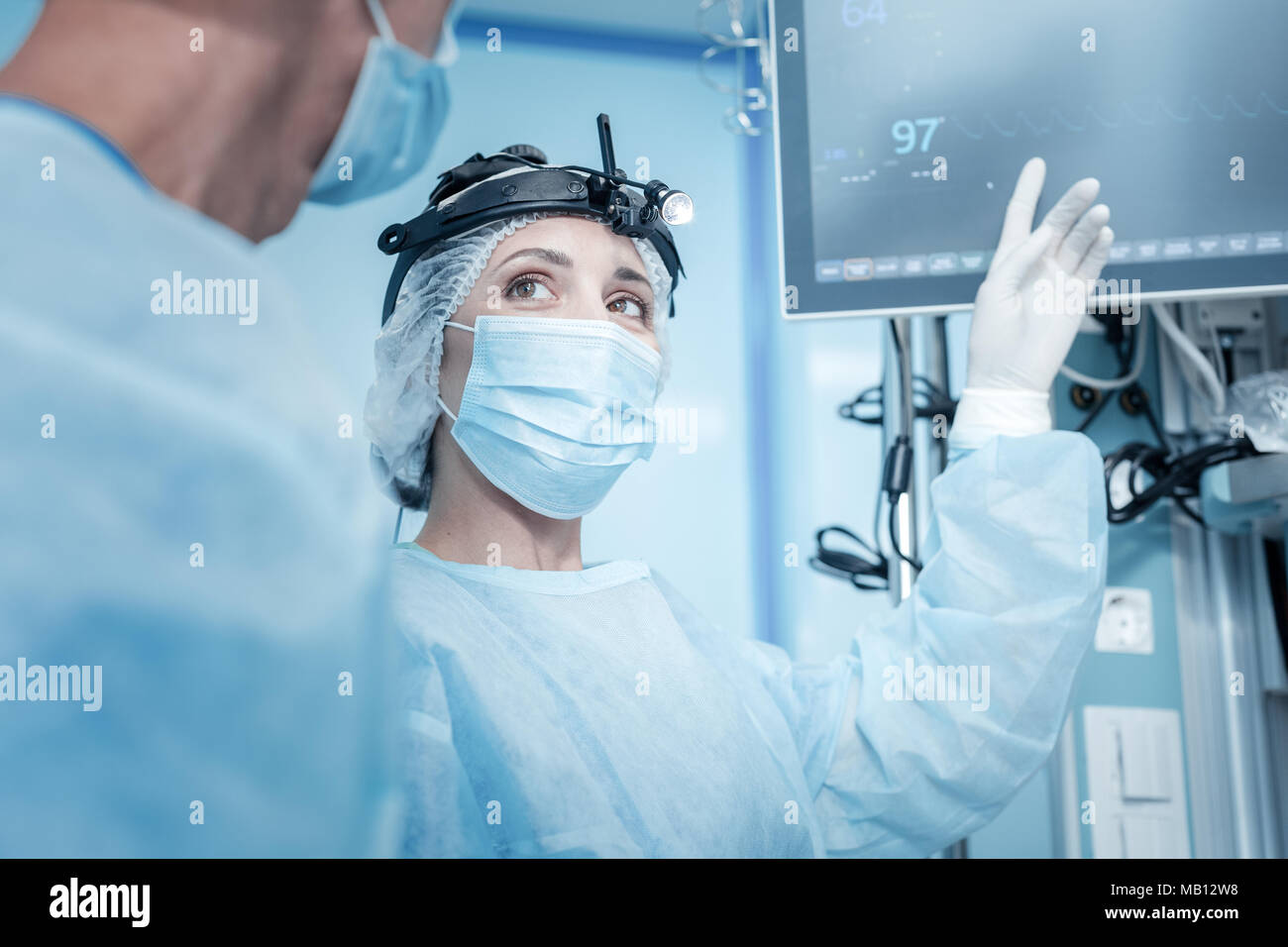 Positive nice surgeon holding her hand up Stock Photo - Alamy
