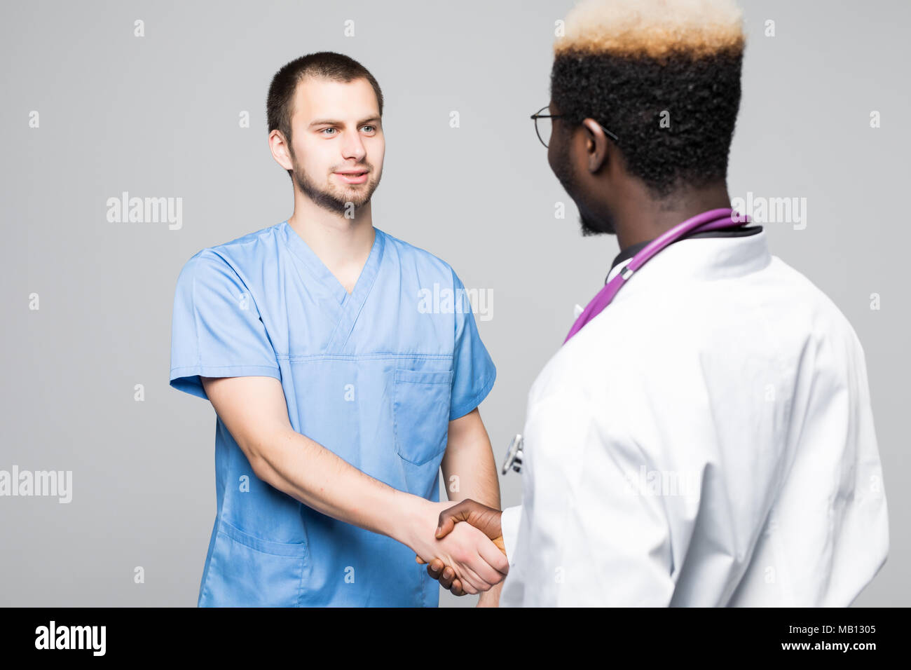 Medical handshake. Two confident doctor standing on gray and shake ...