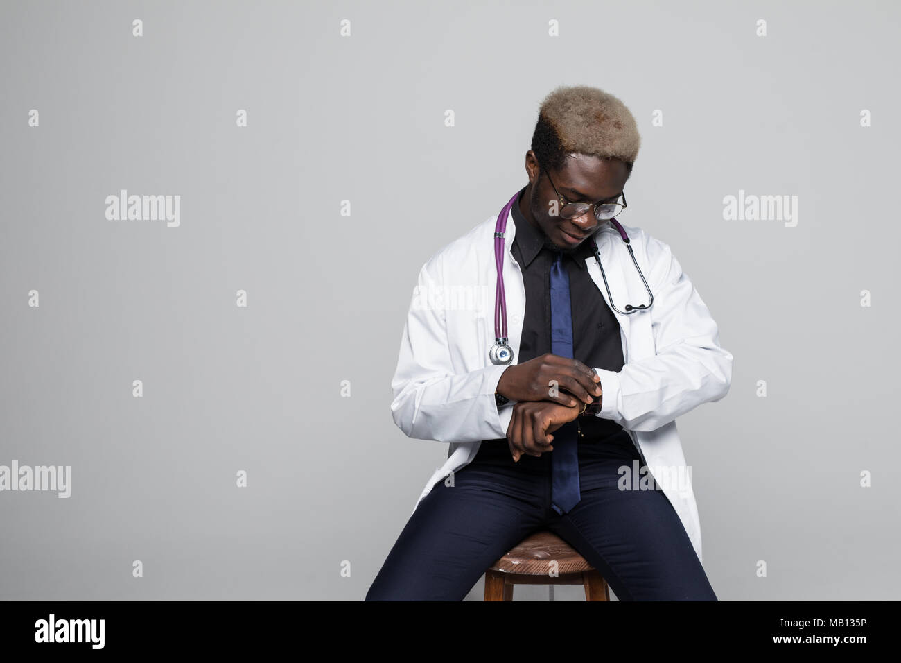 Black doctor portrait sitting on chair isolated on gray Stock Photo - Alamy