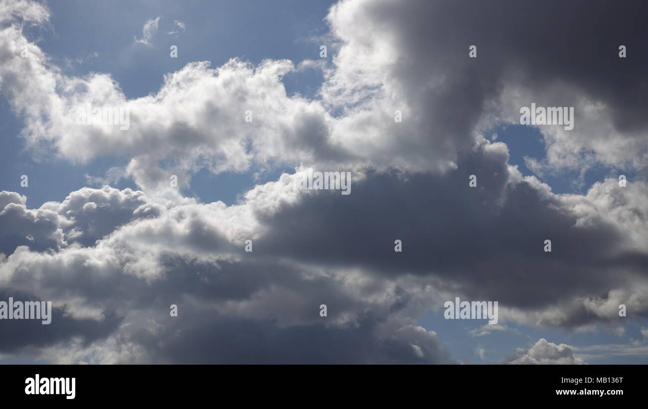 Beautiful billowing rolling clouds in a blue sky on a bright sunny day ...