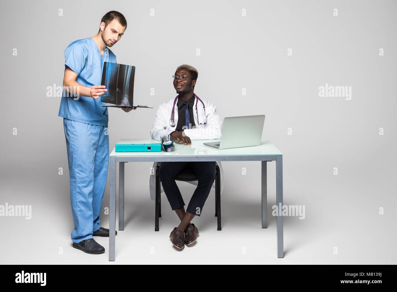Young doctors discussing diagnosis in bright office. Two doctors ...