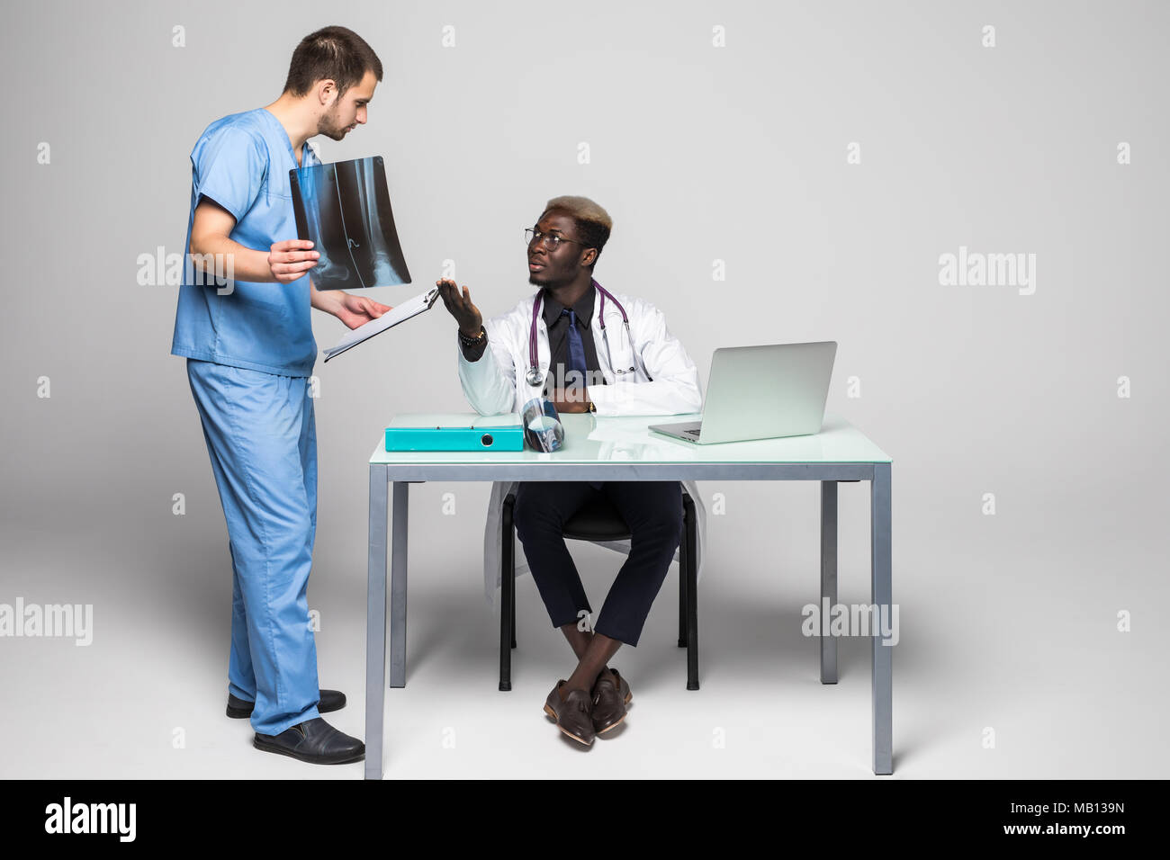 Young doctors discussing diagnosis in bright office. Two doctors ...