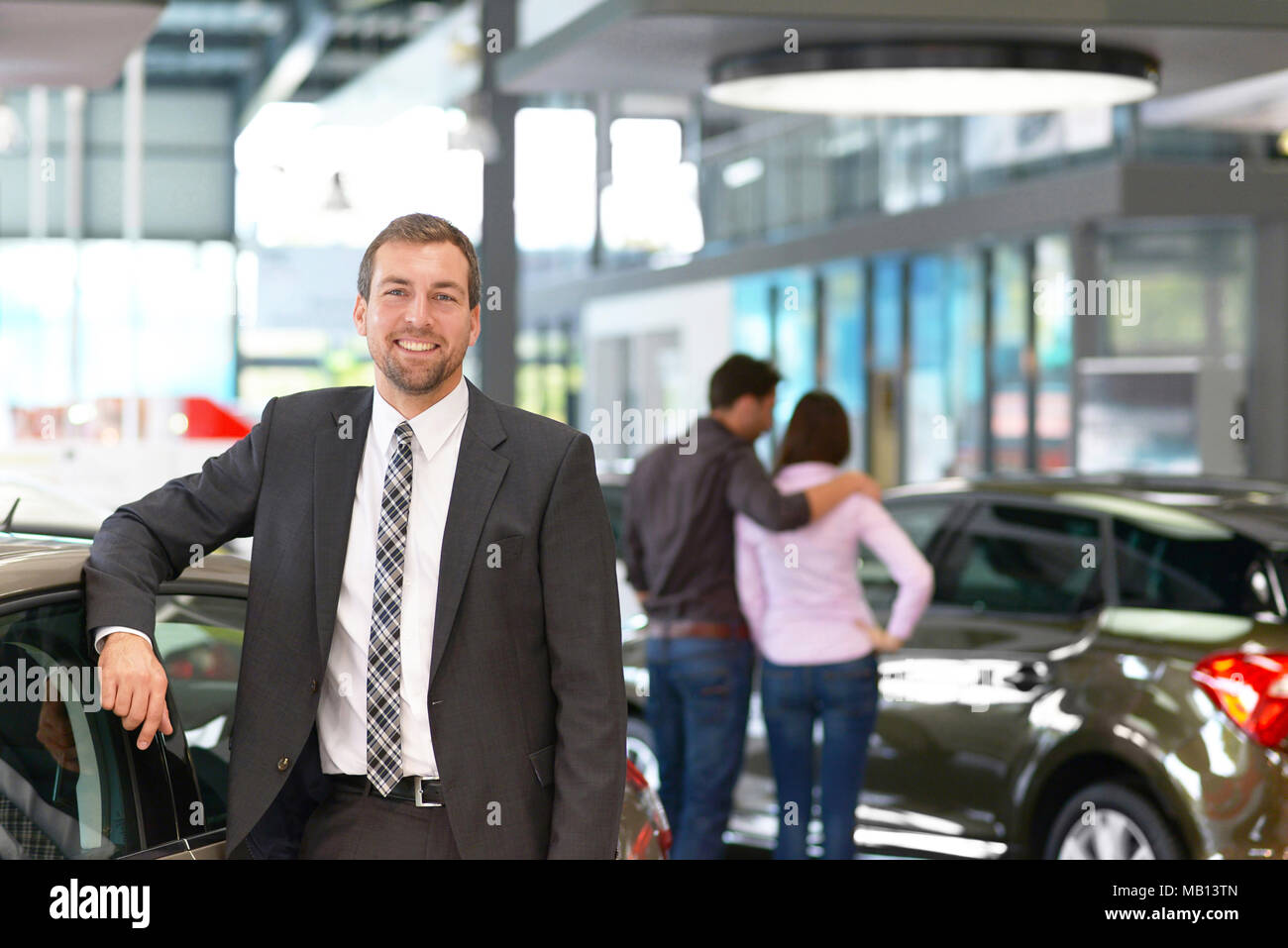 successful businessman in a car dealership - sale of vehicles to ...