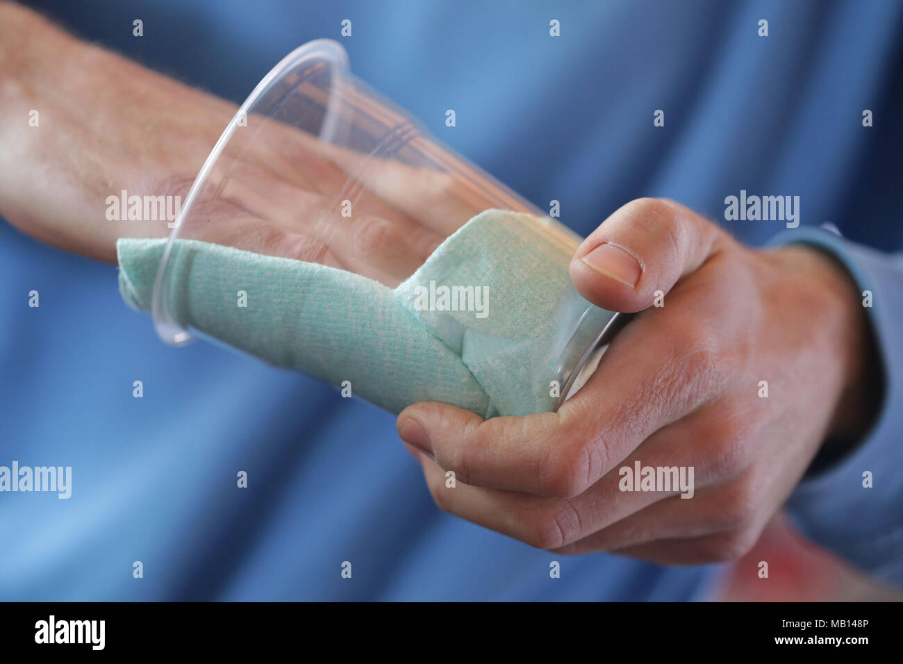 Cleaning transparent plastic cup with tirquiose cloth Stock Photo - Alamy