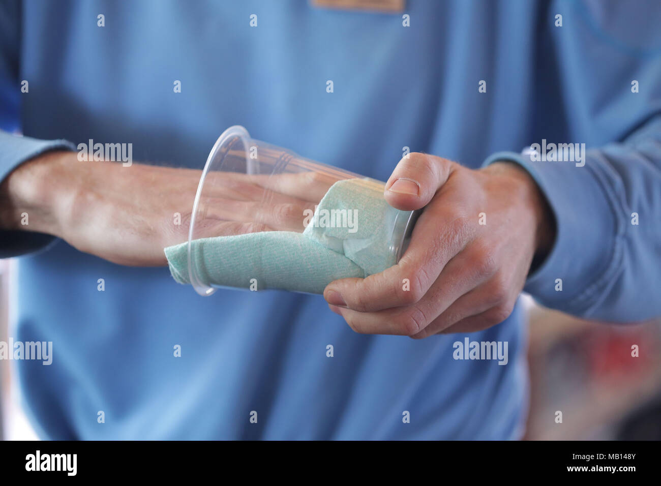 Cleaning transparent plastic cup with tirquiose cloth Stock Photo - Alamy