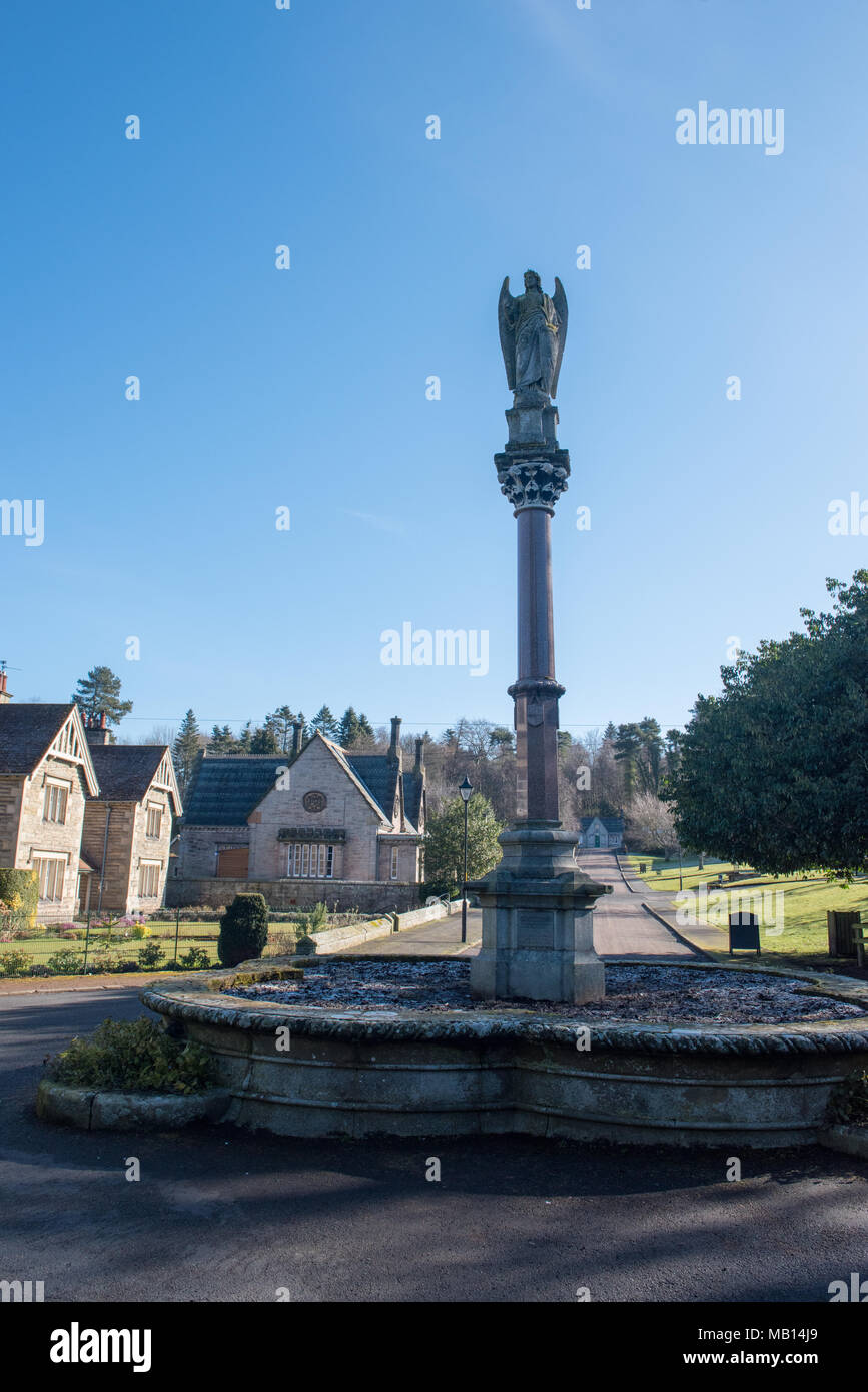 Angel-topped column and stone fountain in historic British village ...